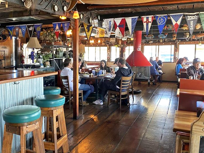 Where nautical flags meet wooden beams and conversation flows as freely as the drinks. The slanted floor reminds you&mdash;you're dining on water.