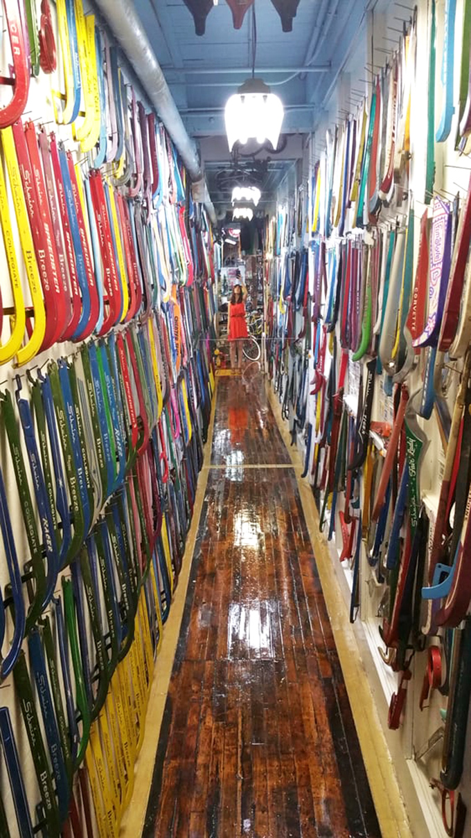 A corridor lined with colorful handlebars creates a rainbow tunnel effect. Like walking through a kaleidoscope designed by bicycle enthusiasts.