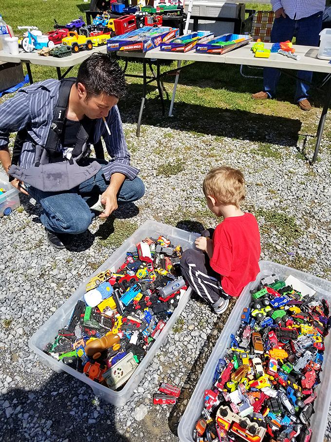 Toy paradise! A young treasure hunter contemplates his next acquisition from plastic bins that hold more joy per square inch than any department store.