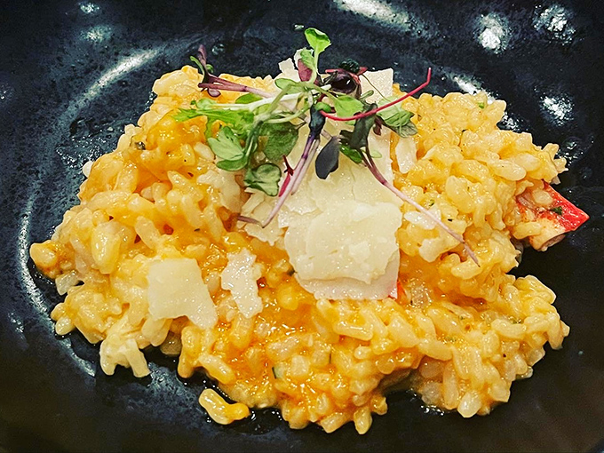 Lobster risotto that glows like edible sunshine, with each grain of rice having achieved creamy perfection. Parmesan shavings are the crowning glory.