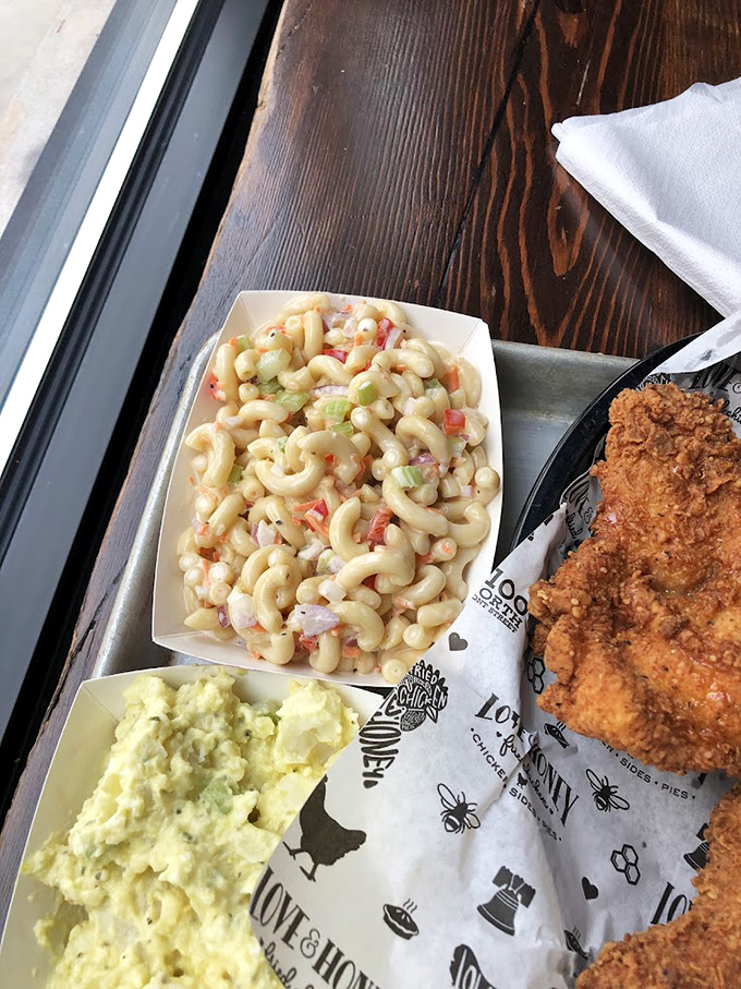 Two sides that refuse to be sidekicks&mdash;creamy mac salad and potato salad flanking the true star. The supporting cast deserves their own standing ovation.