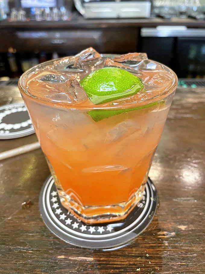 A cocktail that looks like Santa Barbara sunset in a glass, complete with a lime wedge that's not just garnish but an essential supporting actor.