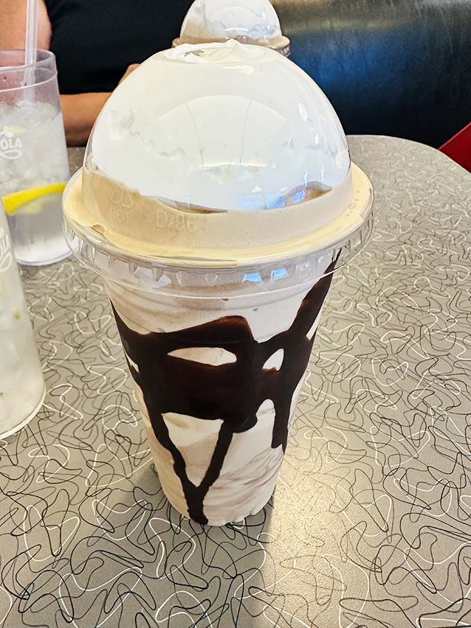 A milkshake so thick the straw stands at attention, with chocolate cascading down the sides like a sweet waterfall of possibility.