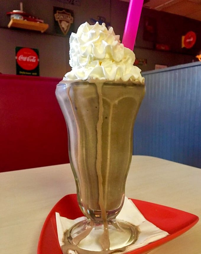 A milkshake so thick the straw stands at attention, topped with a cloud of whipped cream that deserves its own zip code.