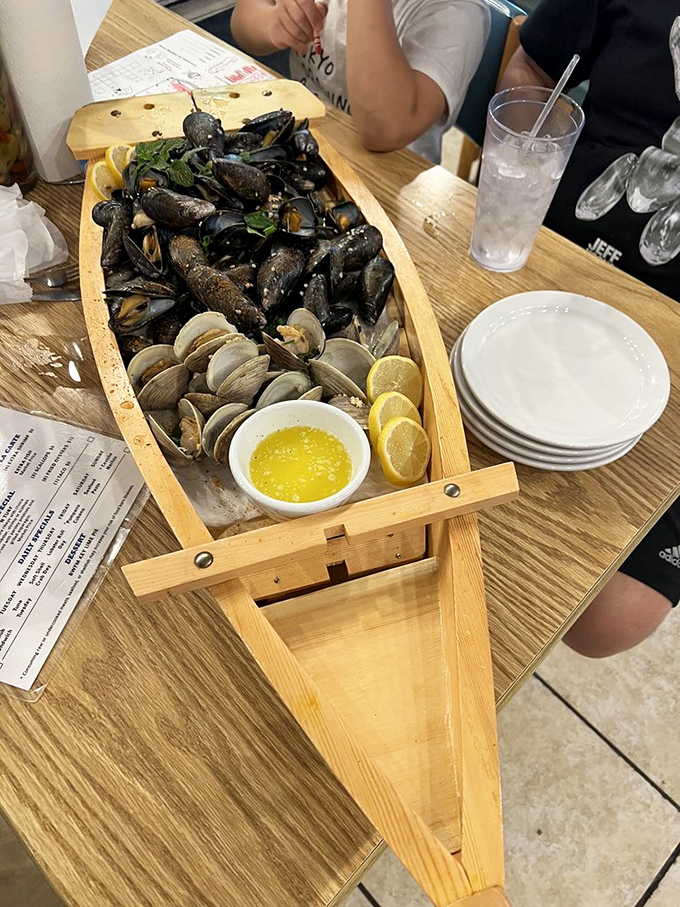 A wooden boat bearing treasures from the deep. These mussels and clams aren't just seafood&mdash;they're an edible maritime adventure with melted butter.