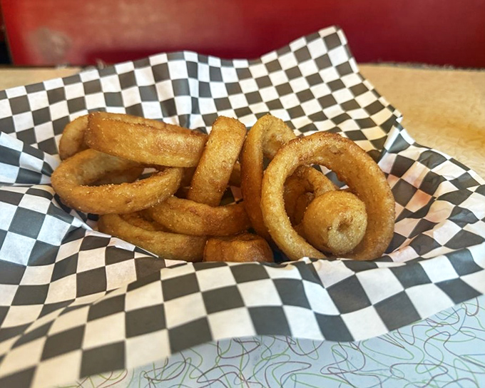 Onion rings wearing their golden armor proudly. Each one audibly announces its presence with a crunch that echoes through the diner.