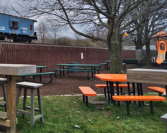 The outdoor seating area, with its mix of picnic tables and playground glimpse, reminds us that simple pleasures still make the best memories.