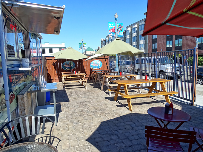 Picnic tables under umbrellas create that perfect casual dining atmosphere where memories are made, napkins are essential, and nobody judges you for that tartar sauce on your chin.
