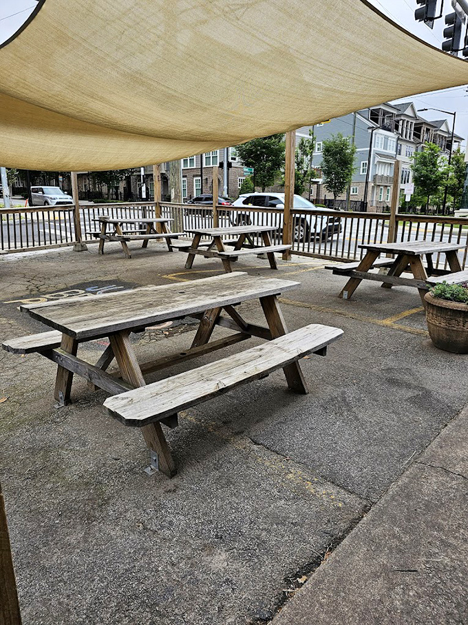 The outdoor seating area offers a shaded respite for those willing to wait. These picnic tables have heard more breakfast dreams than a therapist.