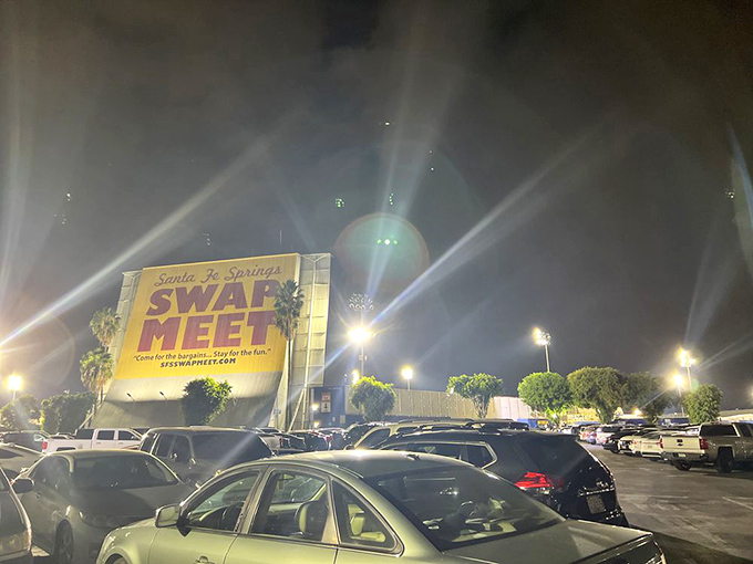 As night falls, the swap meet's massive sign illuminates like a beacon, calling night owls to its Friday evening festivities.