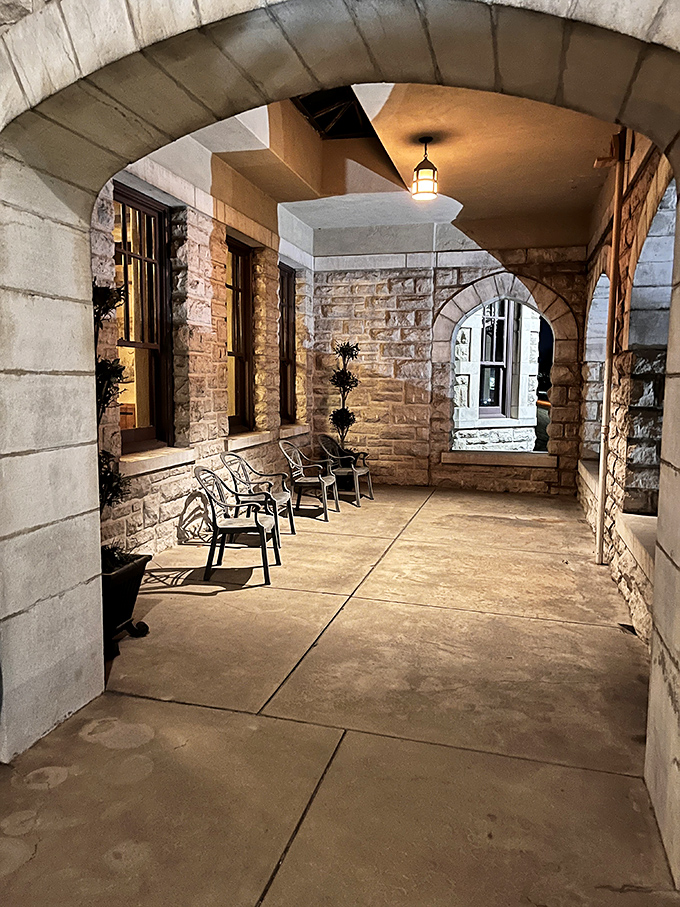 Stone archways frame this peaceful patio area, where the play of light and shadow creates a medieval atmosphere perfect for contemplation.