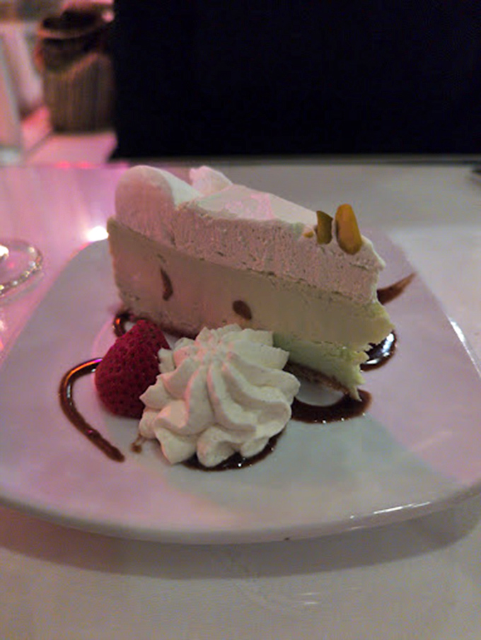 A slice of pistachio cheesecake that makes you consider ordering a second piece before you've finished the first. Strategic dessert planning at its finest.