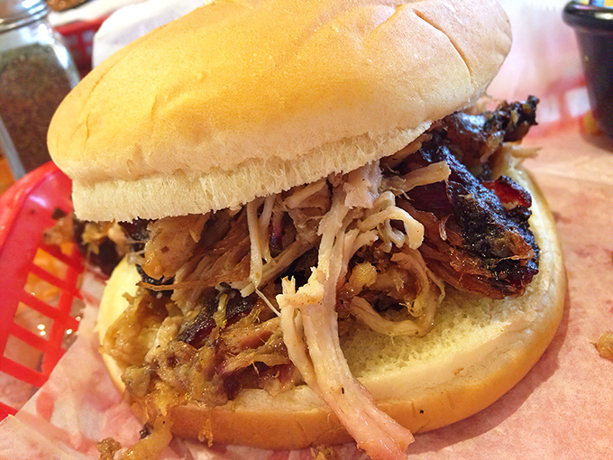 A proper pulled pork sandwich that requires both hands and zero shame. The meat-to-bun ratio here is what mathematicians call "the golden proportion."