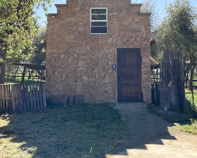 This stucco structure might not scream "castle," but even Camelot needed practical outbuildings. The wooden door adds that perfect rustic touch.