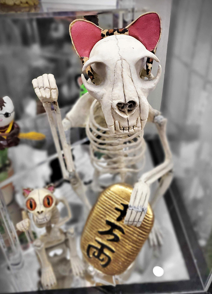 Even in skeletal form, these lucky cats keep waving! This macabre take gives new meaning to "nine lives" while still clutching that golden coin.