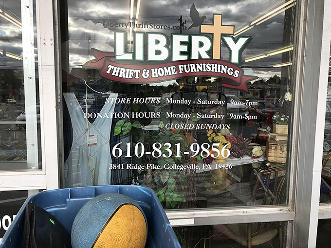 The store's window displays its hours and mission. Behind this glass lies a world where bargain hunting becomes an Olympic-worthy sport.