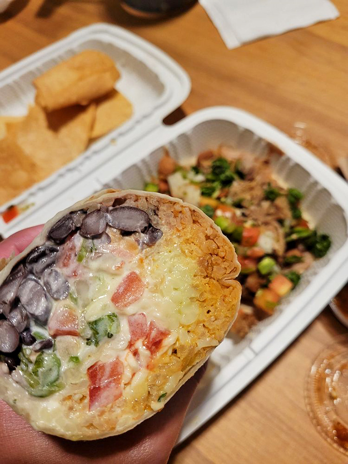 The veggie burrito cross-section reveals the beautiful truth: meatless doesn't mean joyless when avocado, cheese, and fresh vegetables join forces.