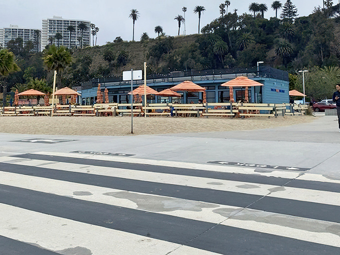 Blue walls and orange umbrellas create a cheerful beachfront escape. Yes, those tables are actually set up right on the sand!