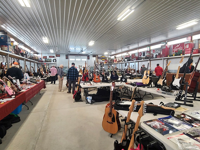 An indoor guitar show features rows of acoustic and electric instruments, drawing music lovers and collectors to browse and trade.