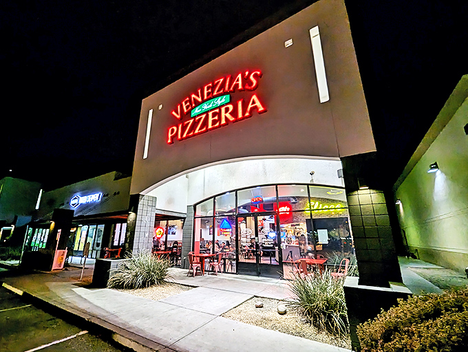 Venezia's neon sign glows like a beacon in the night, promising New York-style slices that transport you straight to Manhattan.
