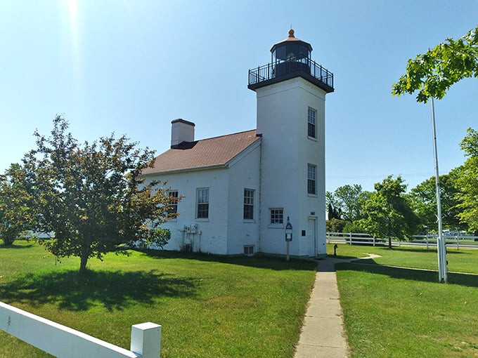 The historic lighthouse stands tall against the bright sky, offering timeless views and peaceful charm along Escanaba&rsquo;s scenic waterfront.