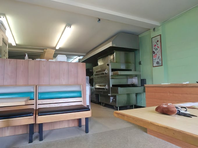 Simple wooden booths and retro vibes create the perfect backdrop for JJ's unforgettable pies. Sometimes the best pizza comes from the quietest places.