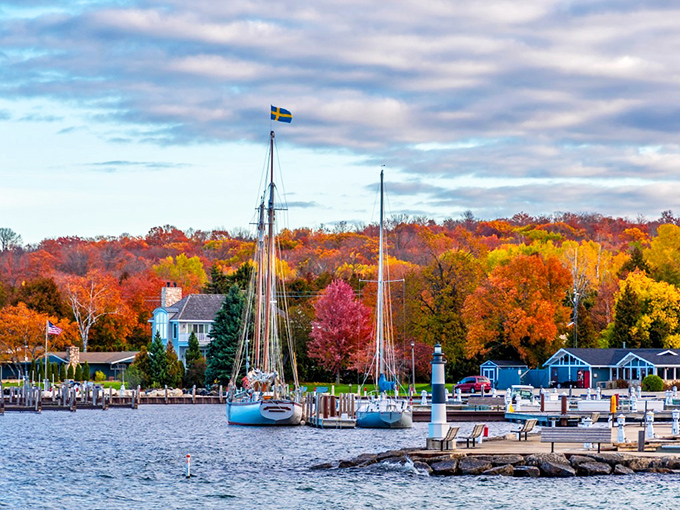 Sailboats rest peacefully in Ephraim's harbor while fall foliage creates a stunning natural frame around the water.