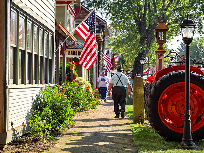 Stars and stripes flutter proudly along charming Main Street, where red tractors remind visitors of agriculture's enduring heritage.