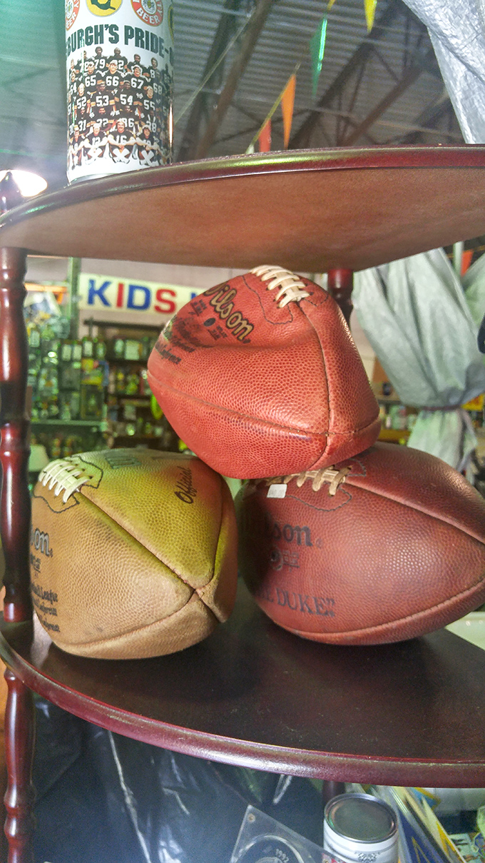 These weathered footballs have seen more Sundays than a pastor, sitting beneath Pittsburgh sports memorabilia waiting for their next huddle.