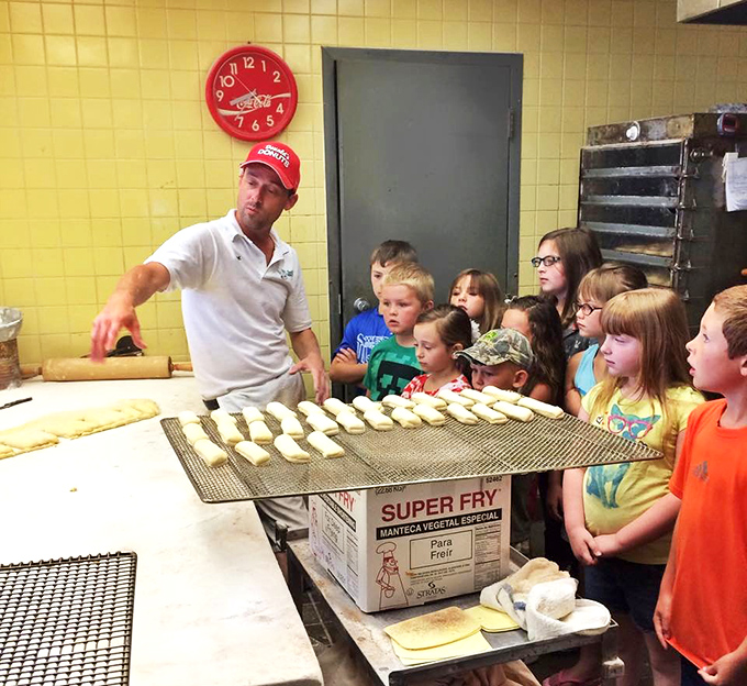 Passing down the sacred art of donut-making to the next generation. These wide-eyed kids are witnessing real magic &ndash; no wizarding school required, just flour, sugar, and tradition.