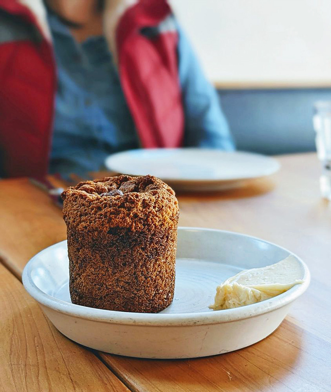 This banana muffin stands tall and proud, like the carb equivalent of a superhero, ready to save your morning with buttery goodness.