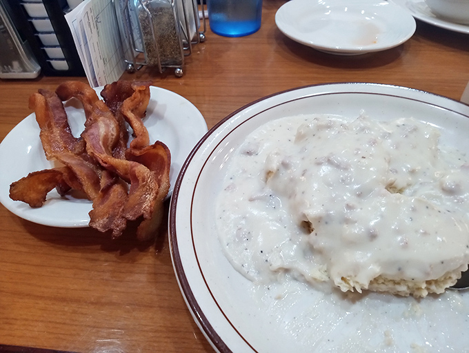 Biscuits and gravy alongside bacon that's achieved perfect crispness. This plate is why elastic waistbands were invented.