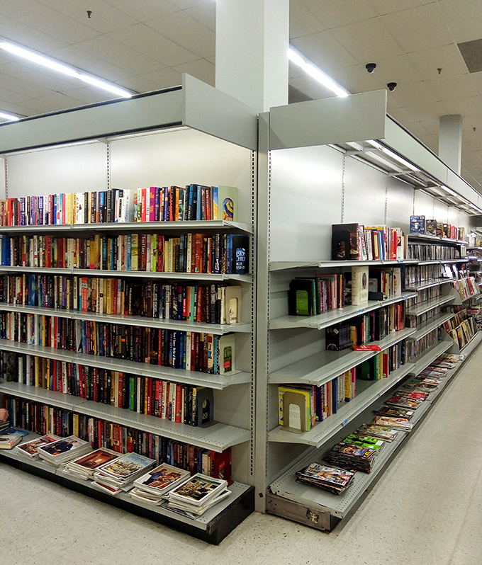 Bibliophile's dream aisle where literary treasures hide in plain sight. First editions and paperback pleasures await at pennies on the dollar.