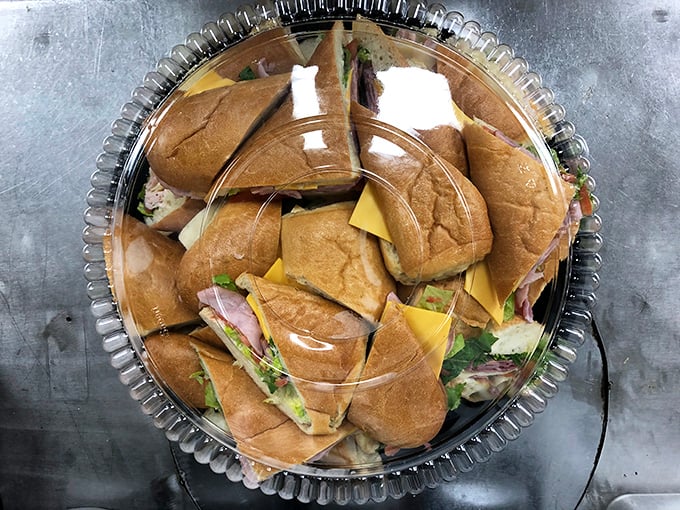 A platter of deli sandwiches arranged in a perfect circle—like a support group for bread and fillings. Lunch meeting? Problem solved.