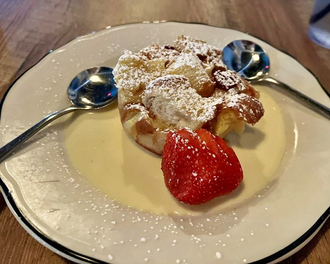 Bread pudding that would make your grandmother both jealous and proud. That strawberry isn't garnish &ndash; it's a pop of color in a symphony of sweetness.