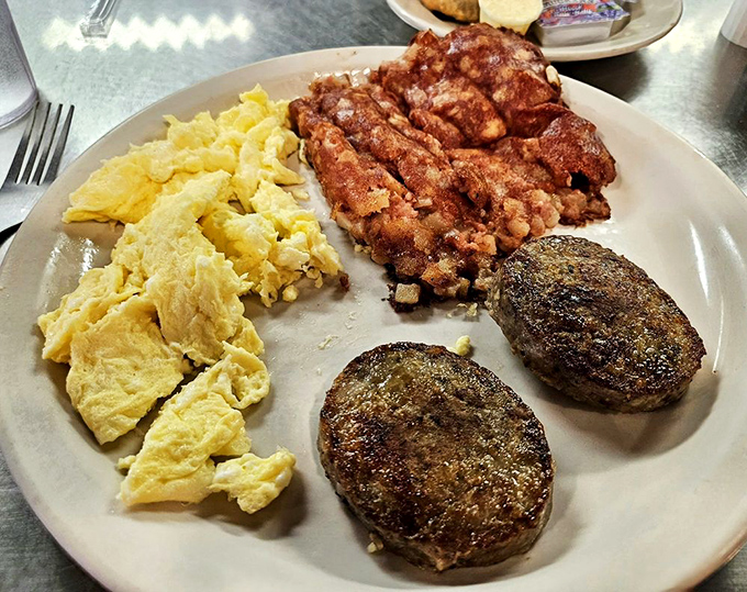 Breakfast perfection on a plate: scrambled eggs, crispy bacon, and sausage patties that make hitting the snooze button seem like a criminal offense.