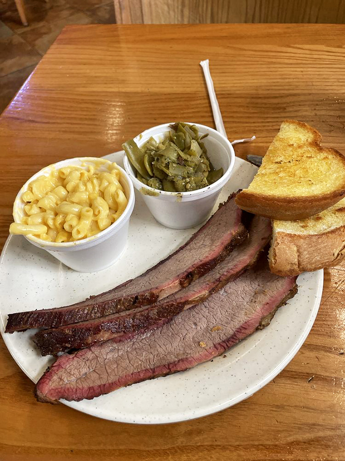 Brisket sliced thin enough to read through but packed with enough flavor to write home about, flanked by Texas toast and proper sides.