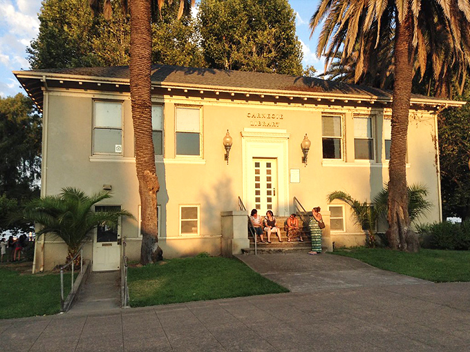 People gather on the steps of this historic building at golden hour, when conversations flow as easily as the nearby lake waters.