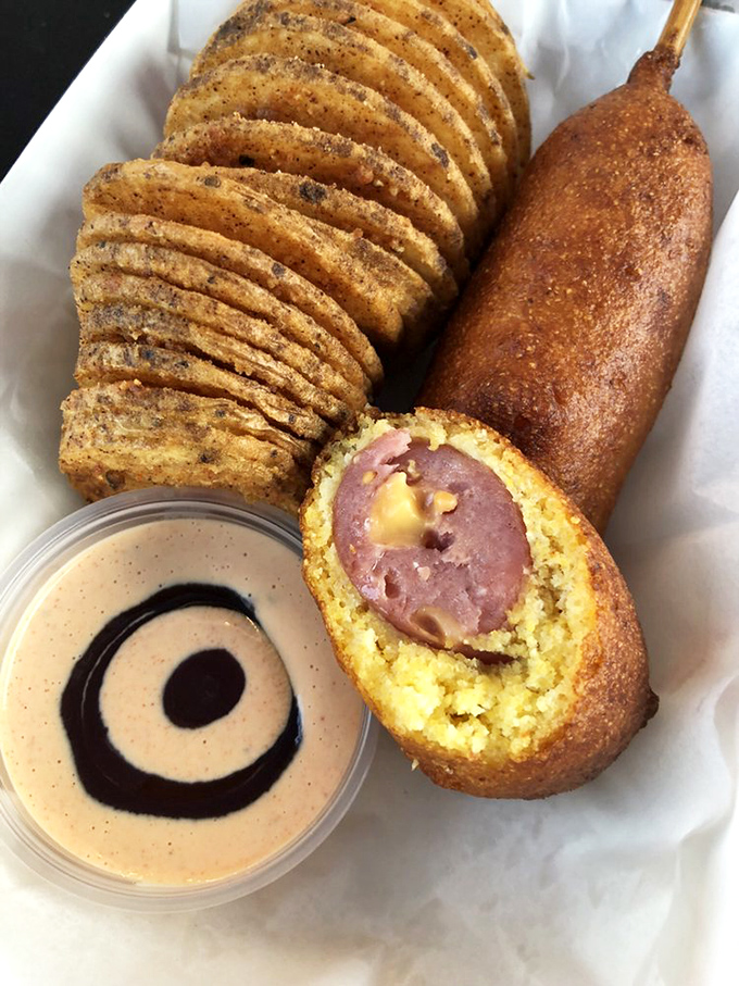 Cornbread-wrapped sausage perfection served with creamy dipping sauce - carnival food elevated to an art form worth celebrating.