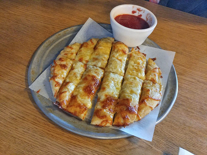 These cheesy breadsticks arrive golden and glistening, ready to ruin your dinner in the best way.