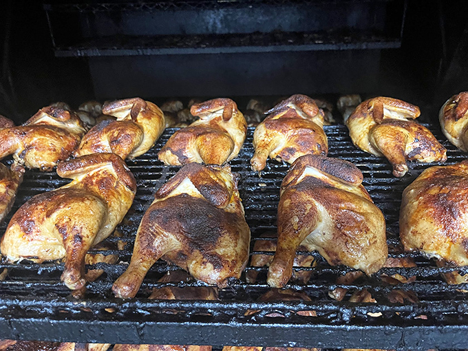 Chicken quarters basking in smoky glory. Like sunbathers on a grill beach, they've achieved the perfect golden tan.