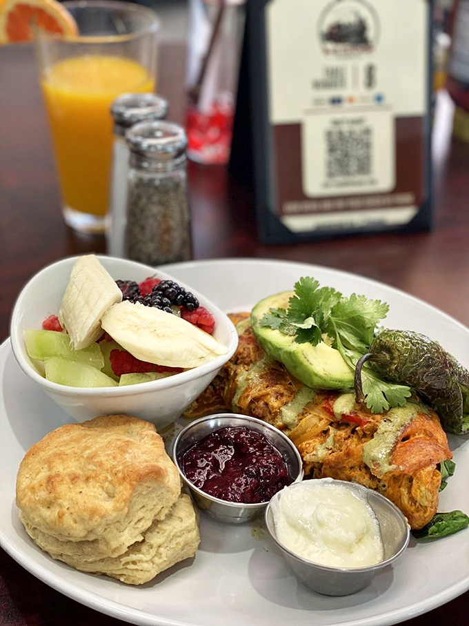 Breakfast with attitude: Fresh fruit, homemade biscuit, and what appears to be a southwestern-inspired egg creation. Morning glory on a plate!