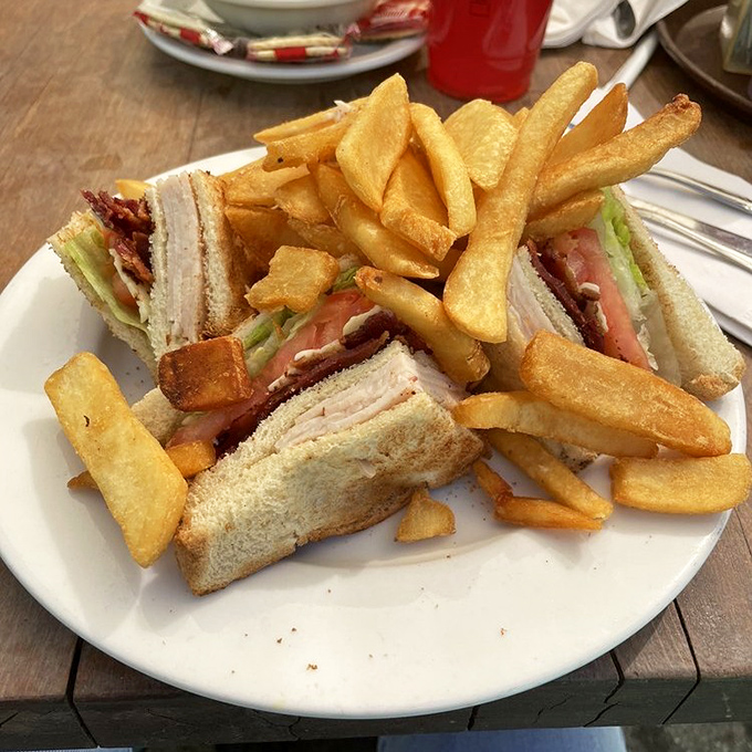 The club sandwich: three layers of bread engineering that has sustained American lunches since the Roaring Twenties. Those golden fries aren't just sides&mdash;they're co-stars.