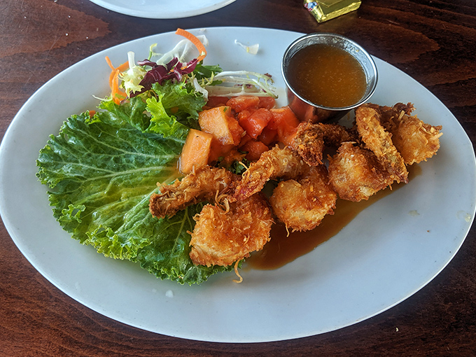 Coconut shrimp arranged like they're posing for their seafood glamour shot. The dipping sauce is just their way of showing off.