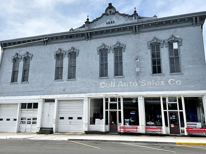 This pale blue commercial building wears its history in faded lettering, like an elderly gentleman who still dresses up despite having nowhere particular to go.