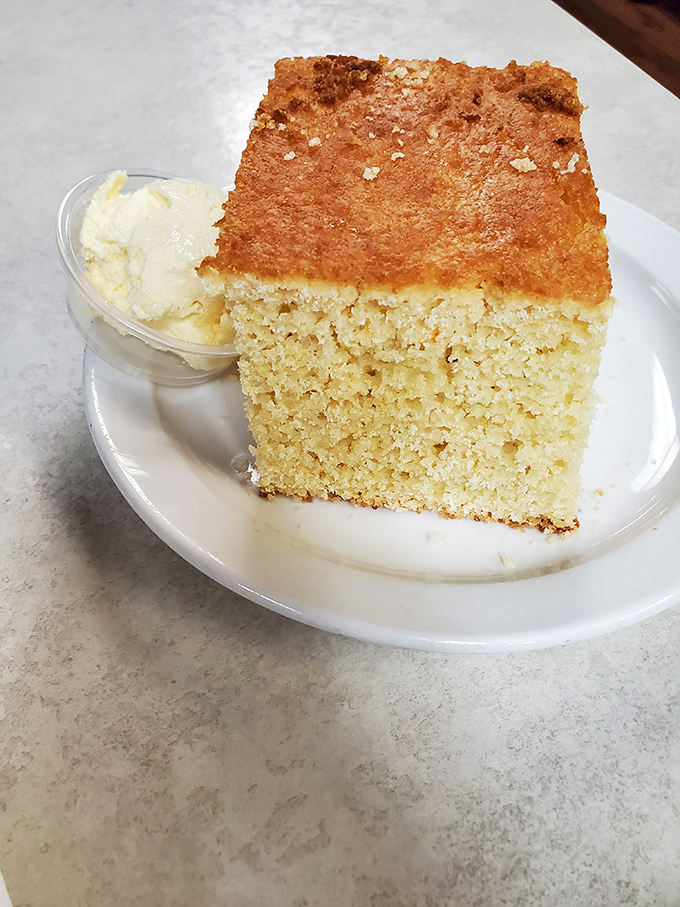 A slice of cornbread that walks the perfect line between sweet and savory, with a golden crust that gives way to moist, tender crumb.