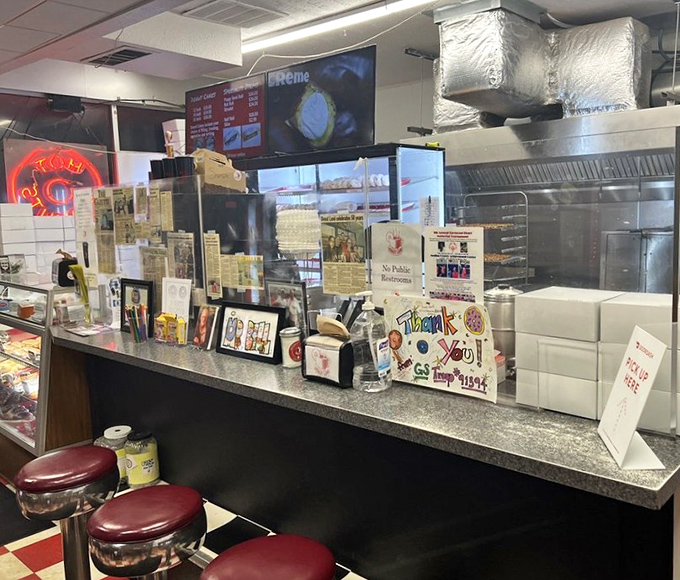 Behind the counter where donut magic happens daily. Like Willy Wonka's factory, but with less singing and more frying.