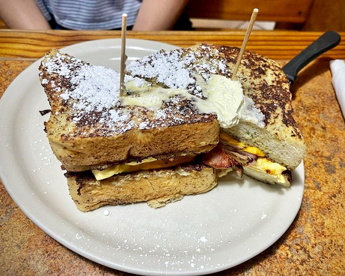 The Cracker Cristo sandwich: where French toast meets breakfast sandwich in a powdered sugar snowstorm that would make even Miami jealous.