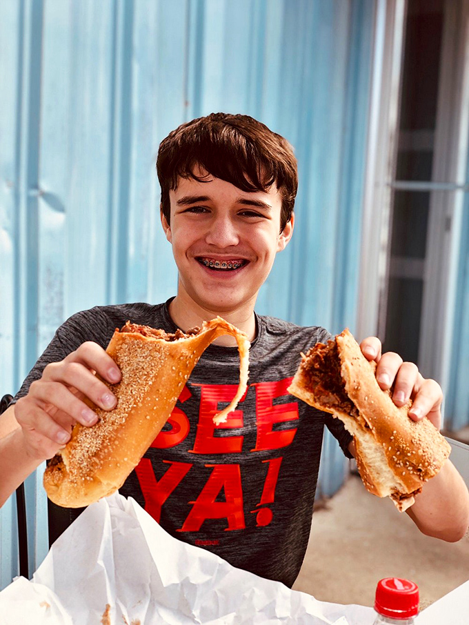 The pure joy of a great cheesesteak captured in one moment – stretchy cheese, perfectly seasoned meat, and the smile that says "I've found my happy place."