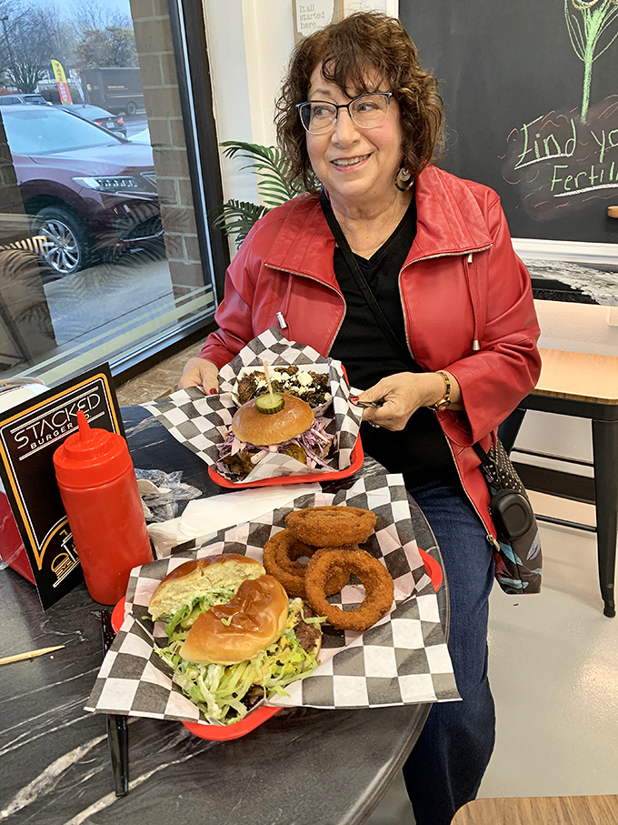 A happy diner showing off her burger bounty&mdash;the universal expression of "I can't believe I get to eat this."